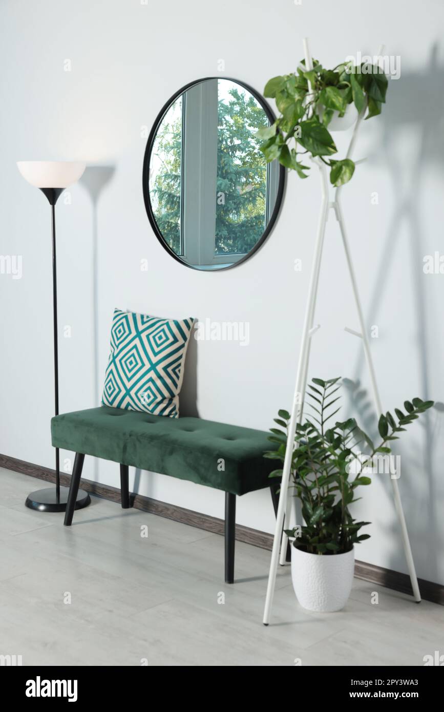 Stylish round mirror on white wall over bench in room Stock Photo - Alamy