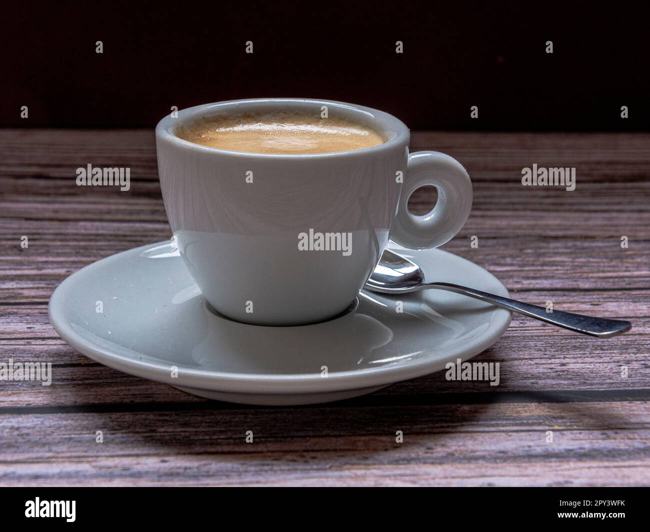 Cup of coffee with spoon on a rustic background. It has negative space ...
