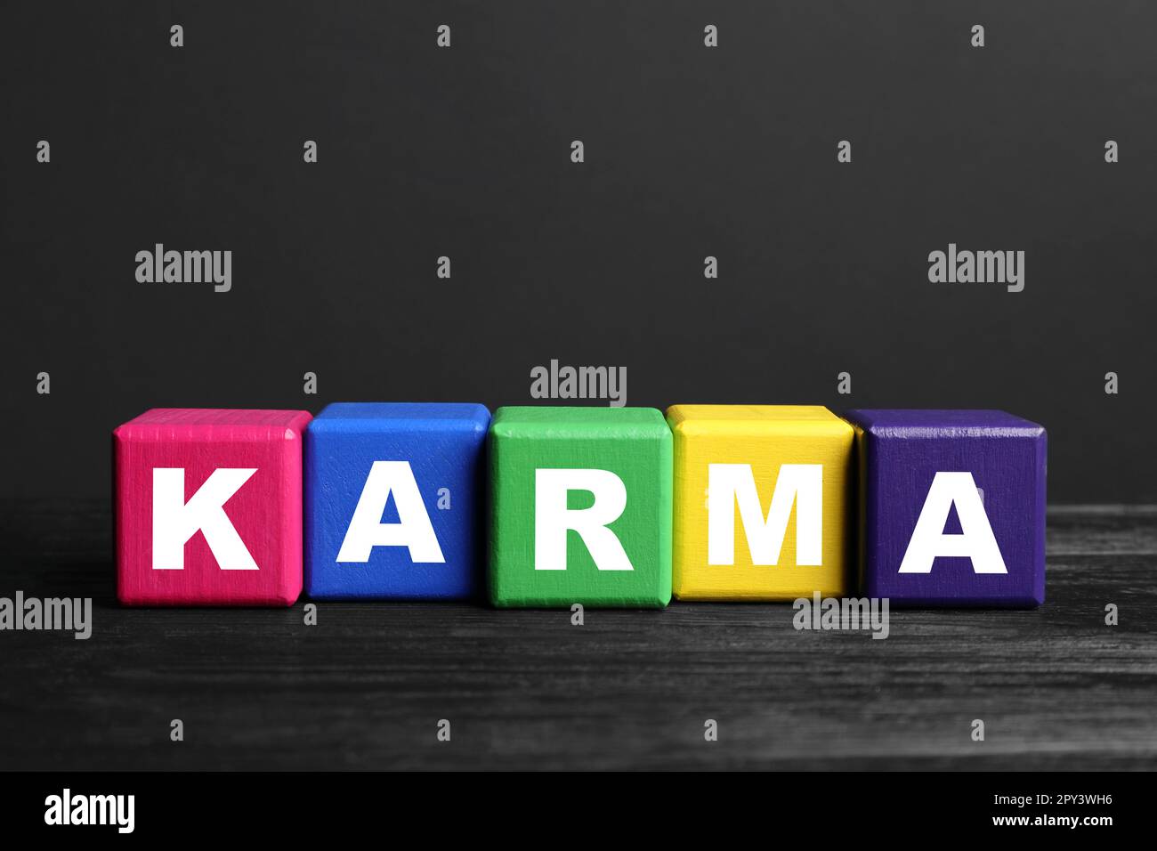 Word Karma made of colorful cubes with letters on black wooden table ...