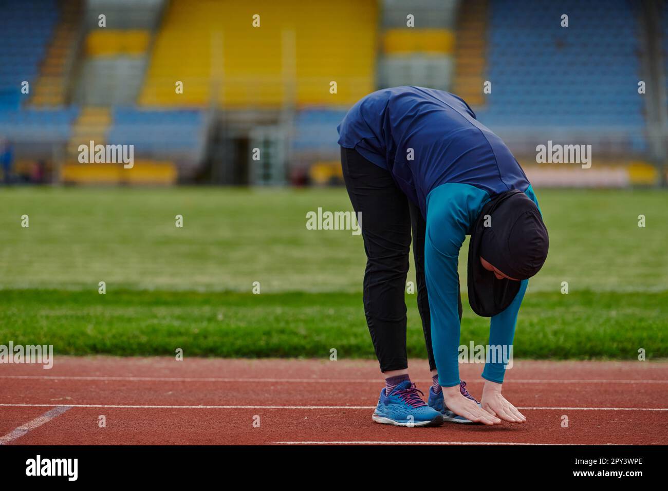 A Muslim woman in a burqa, an Islamic sports outfit, is doing body ...