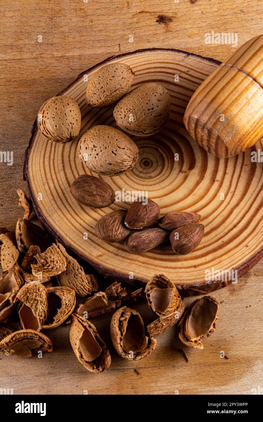 Starting almonds on a wood, with a mace wood. Warm and rustic atmosphere Stock Photo - Alamy
