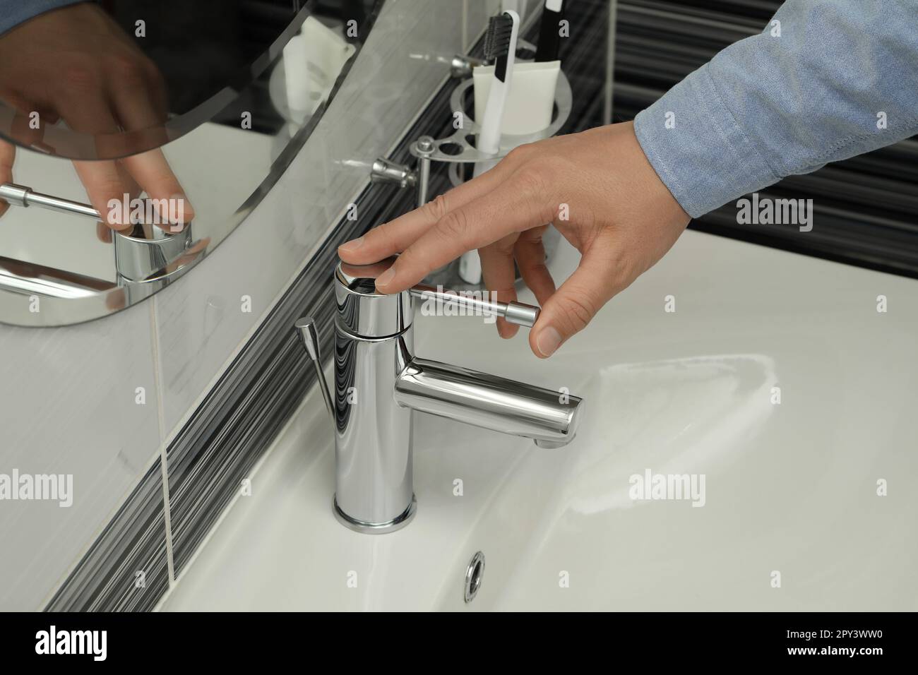 Man using water tap in bathroom, closeup Stock Photo - Alamy