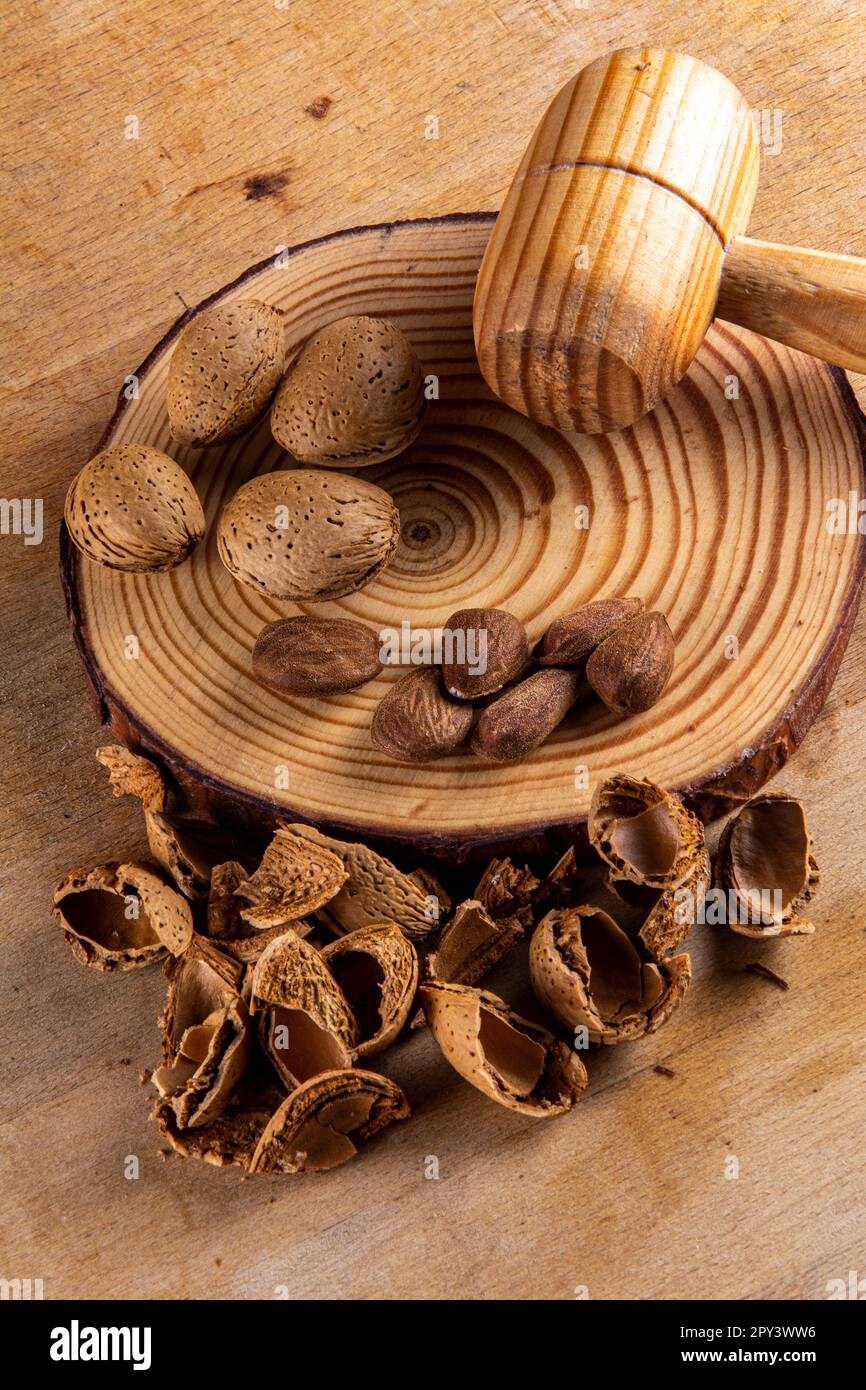 Starting almonds on a wood, with a mace wood. Warm and rustic atmosphere Stock Photo - Alamy