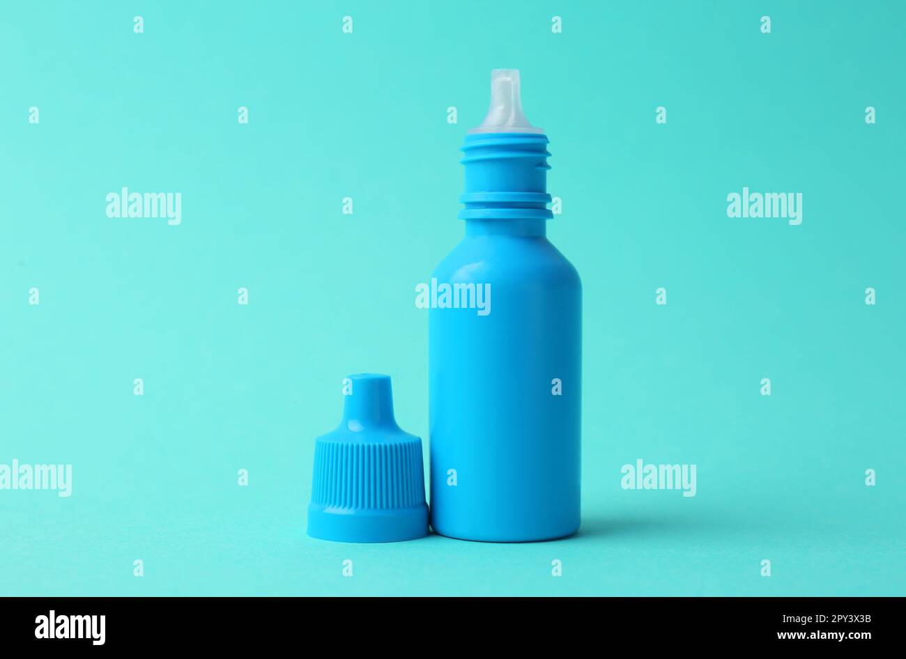 Bottle of medical drops on turquoise background Stock Photo - Alamy