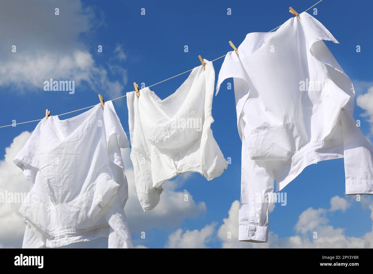 Clean clothes hanging on washing line against sky. Drying laundry Stock ...