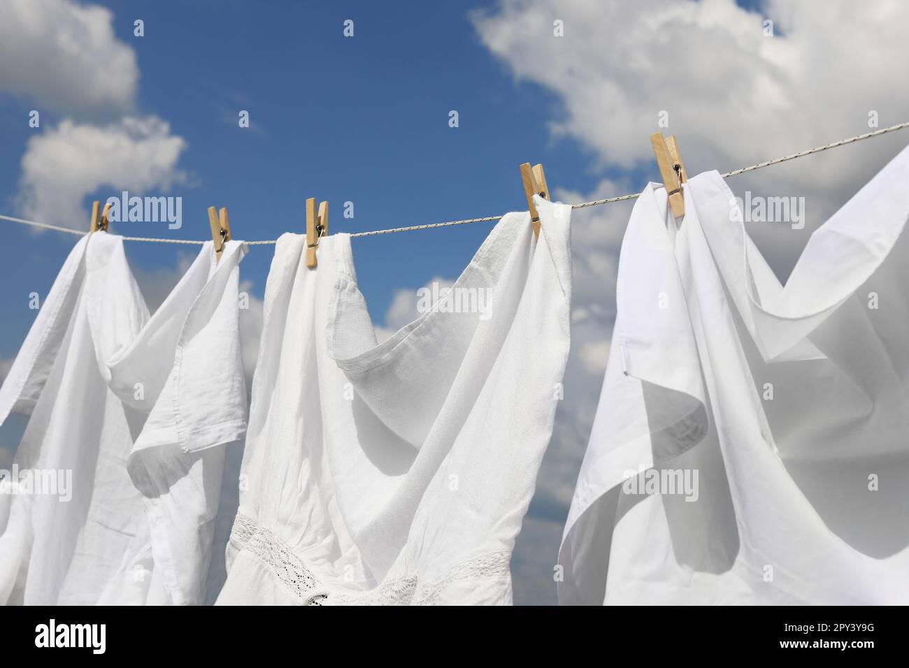 Clean clothes hanging on washing line against sky. Drying laundry Stock ...