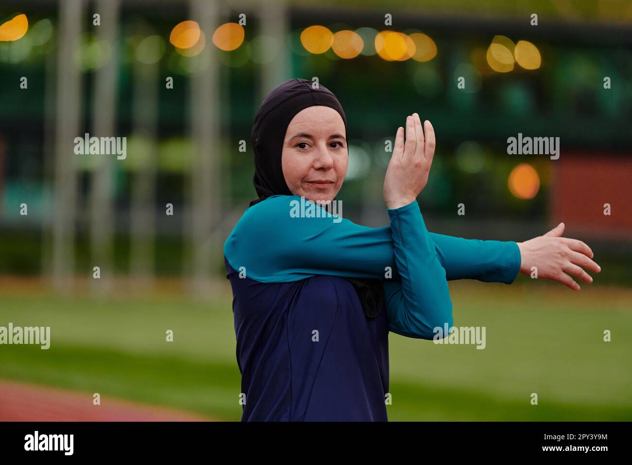 A Muslim woman in a burqa, an Islamic sports outfit, is doing body ...