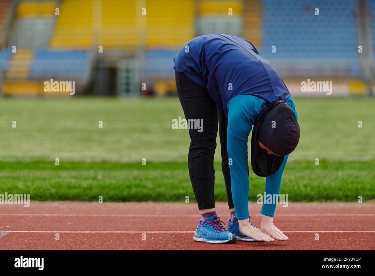 A Muslim woman in a burqa, an Islamic sports outfit, is doing body ...