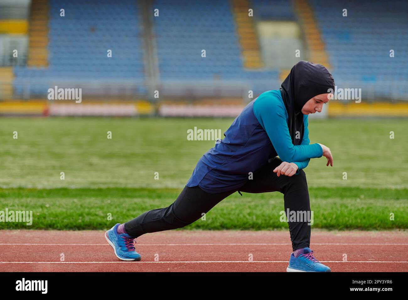 A Muslim woman in a burqa, an Islamic sports outfit, is doing body ...