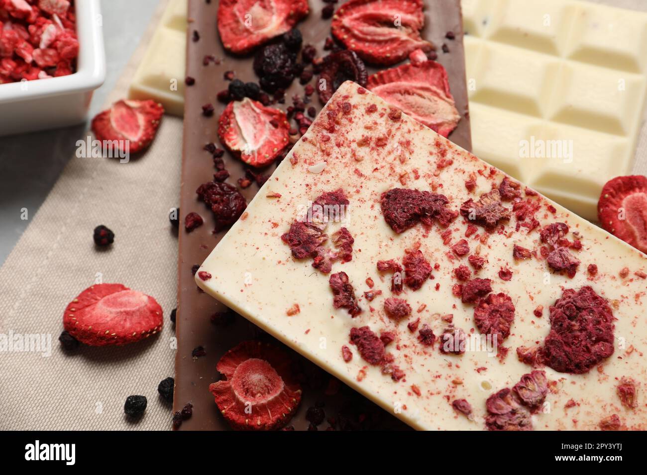 Different chocolate bars with freeze dried fruits on table, closeup ...