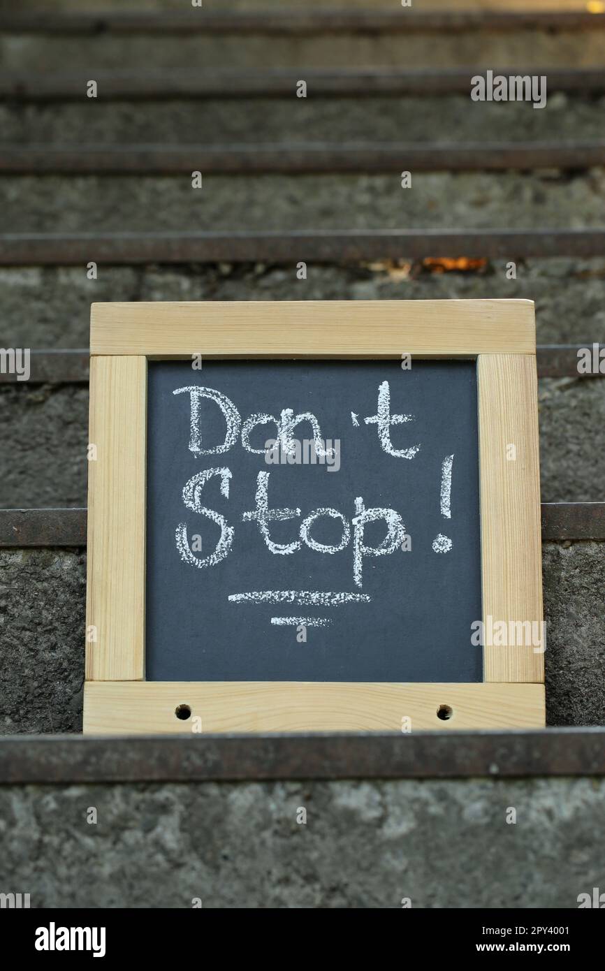 Chalkboard with phrase Don't Stop on stone stairs outdoors Stock Photo ...