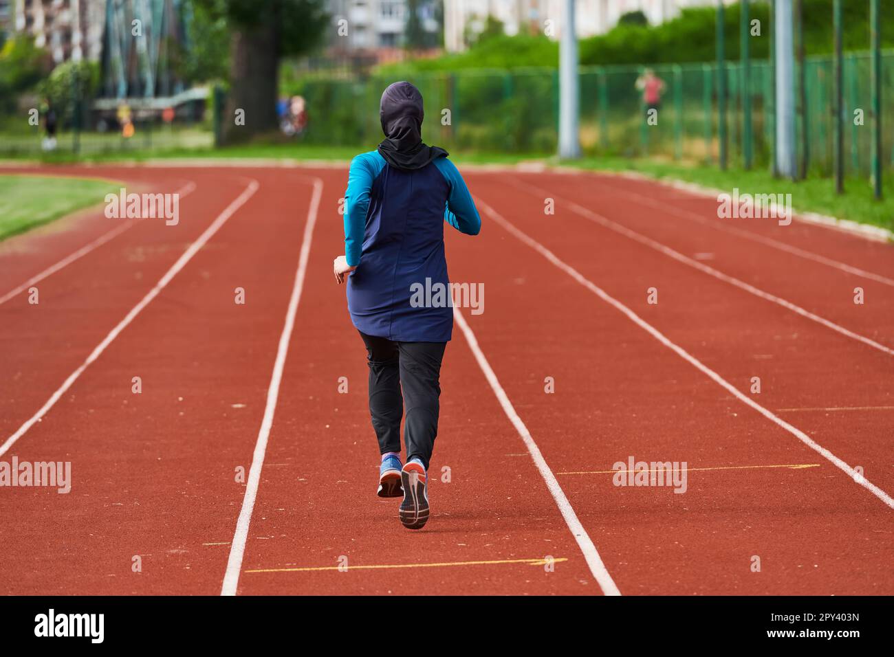 A muslim woman in a burqa sports muslim clothes running on a marathon ...