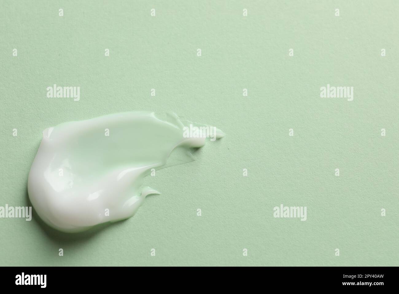 Sample of face cream on light green background, top view. Space for ...