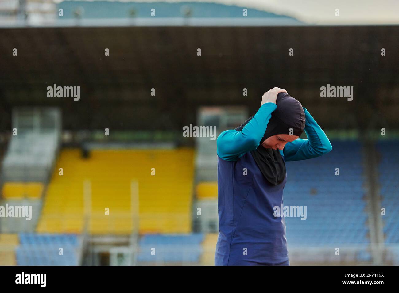 A Muslim woman in a burqa, an Islamic sports outfit, is doing body ...