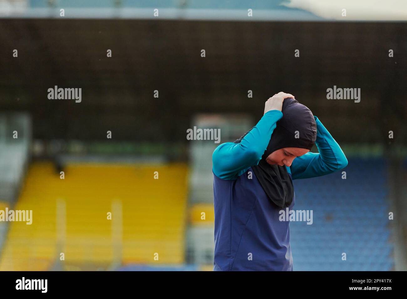 A Muslim woman in a burqa, an Islamic sports outfit, is doing body ...