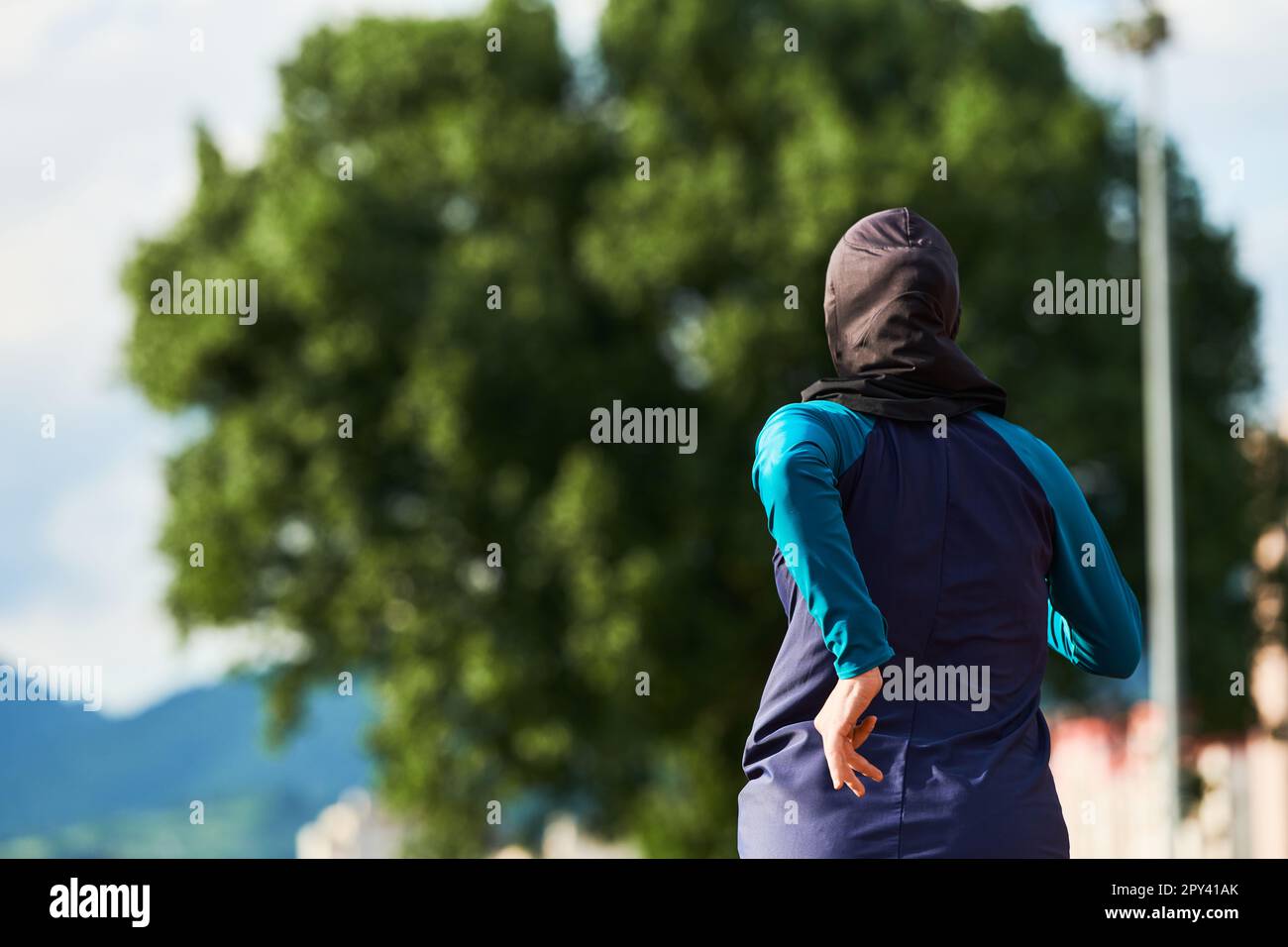 A muslim woman in a burqa sports muslim clothes running on a marathon ...
