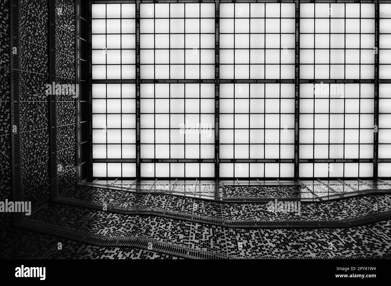 An interior of a modest building with expansive windows and a checkered ...