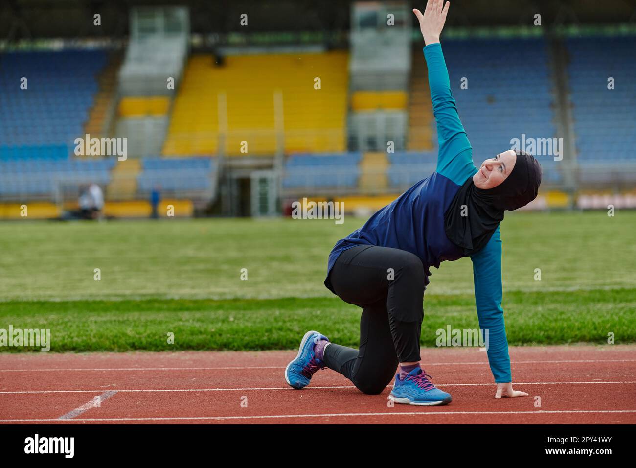 A Muslim woman in a burqa, an Islamic sports outfit, is doing body ...