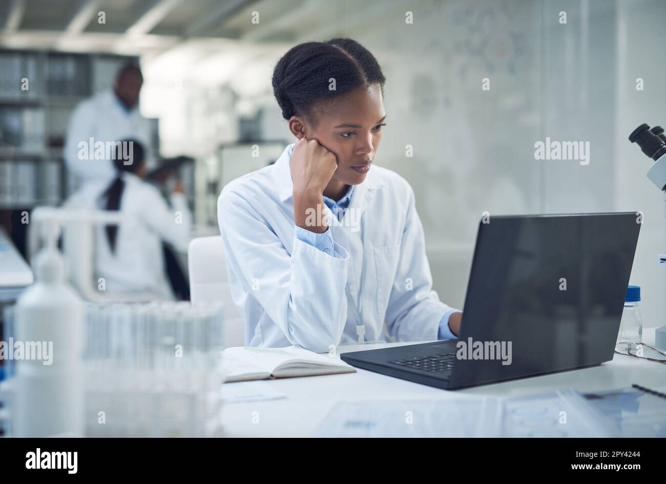 Where theres a why theres a way. a young scientist using a laptop while ...