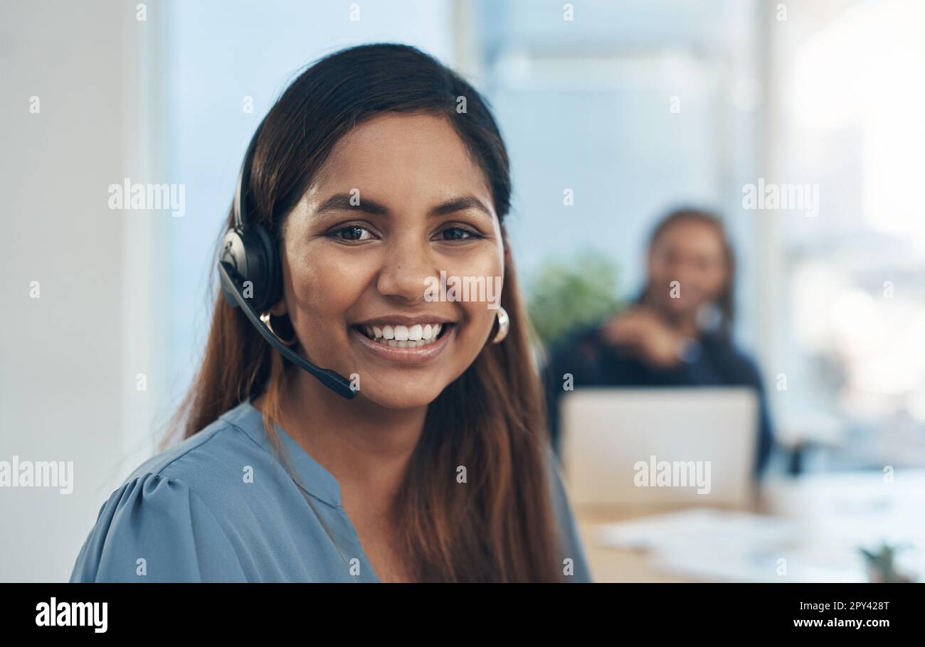 Tending to calls with a big smile and friendly manner. Portrait of a ...