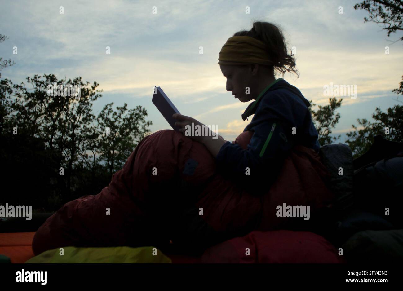 Female hiker reading book while camping Stock Photo - Alamy