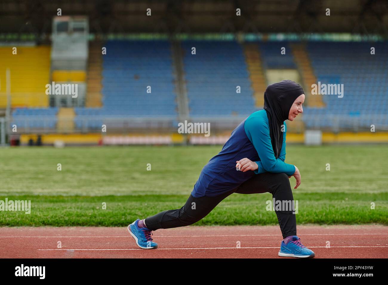 A Muslim woman in a burqa, an Islamic sports outfit, is doing body ...