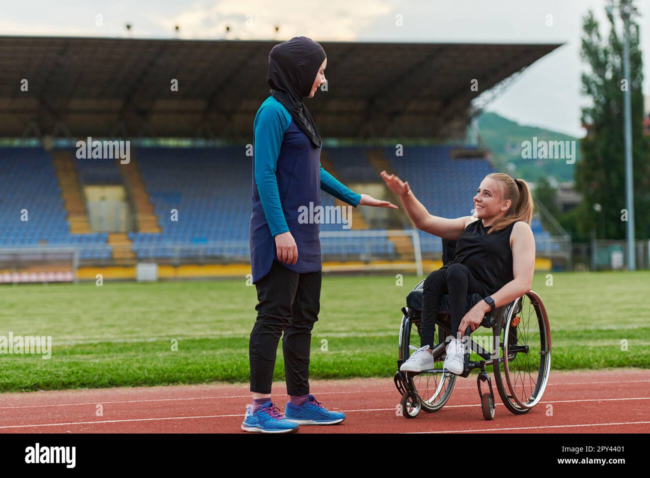 A Muslim woman wearing a burqa supports her friend with disability in a ...