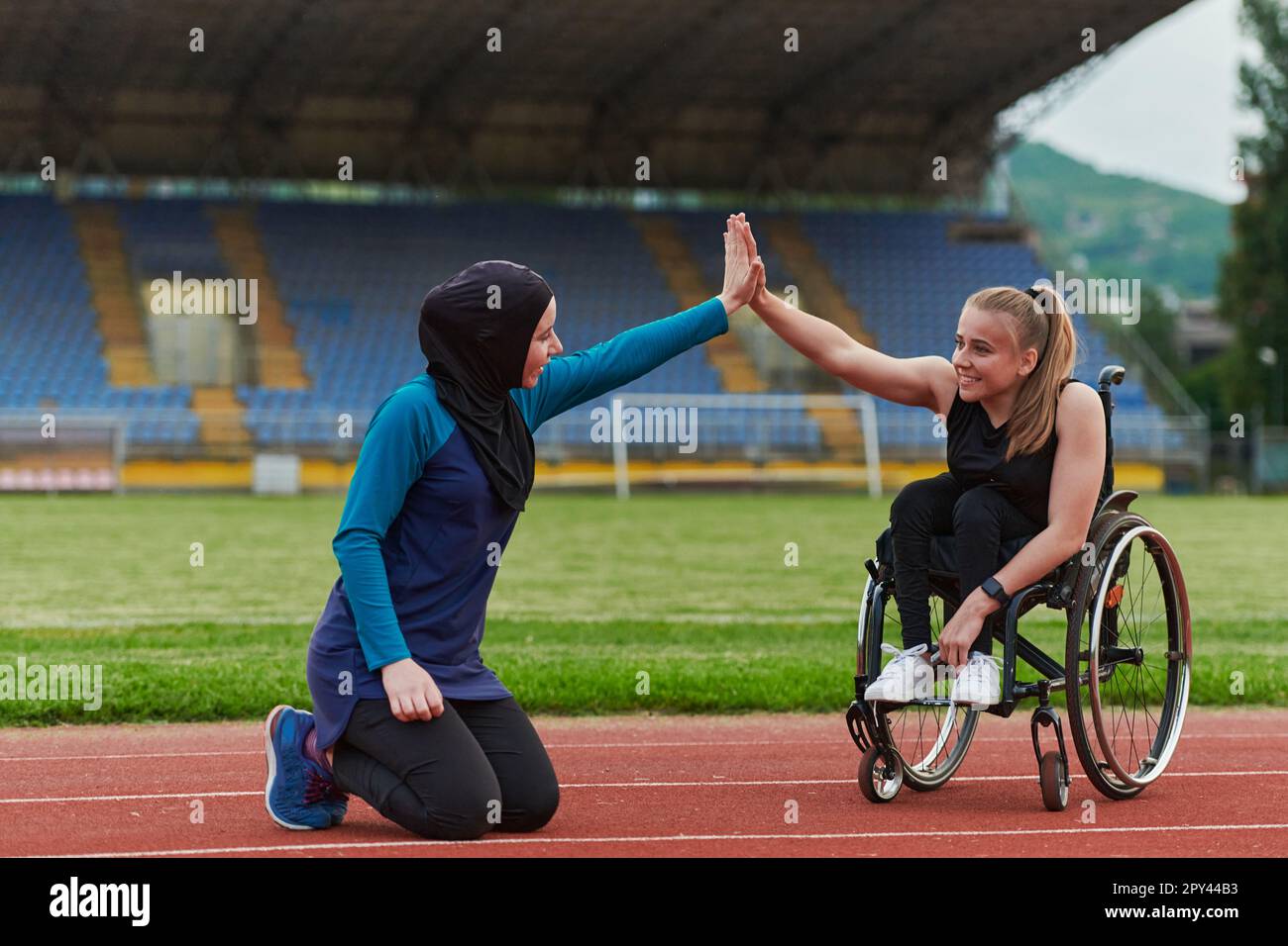A Muslim woman wearing a burqa supports her friend with disability in a ...