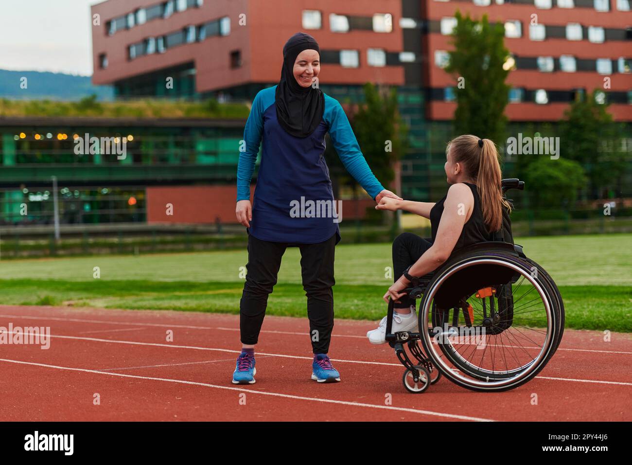 A Muslim woman wearing a burqa supports her friend with disability in a ...