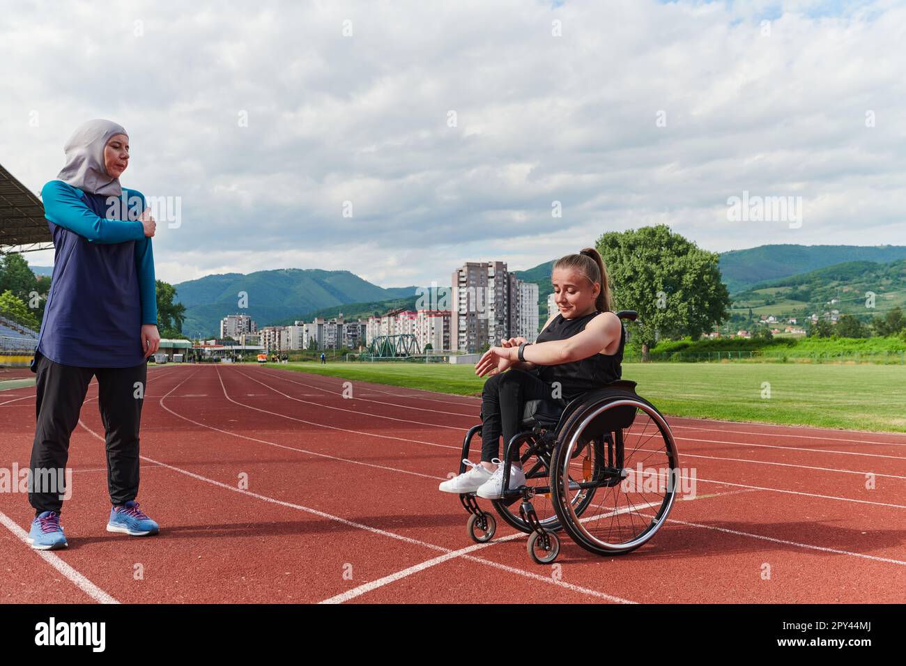 A Muslim woman wearing a burqa supports her friend with disability in a ...