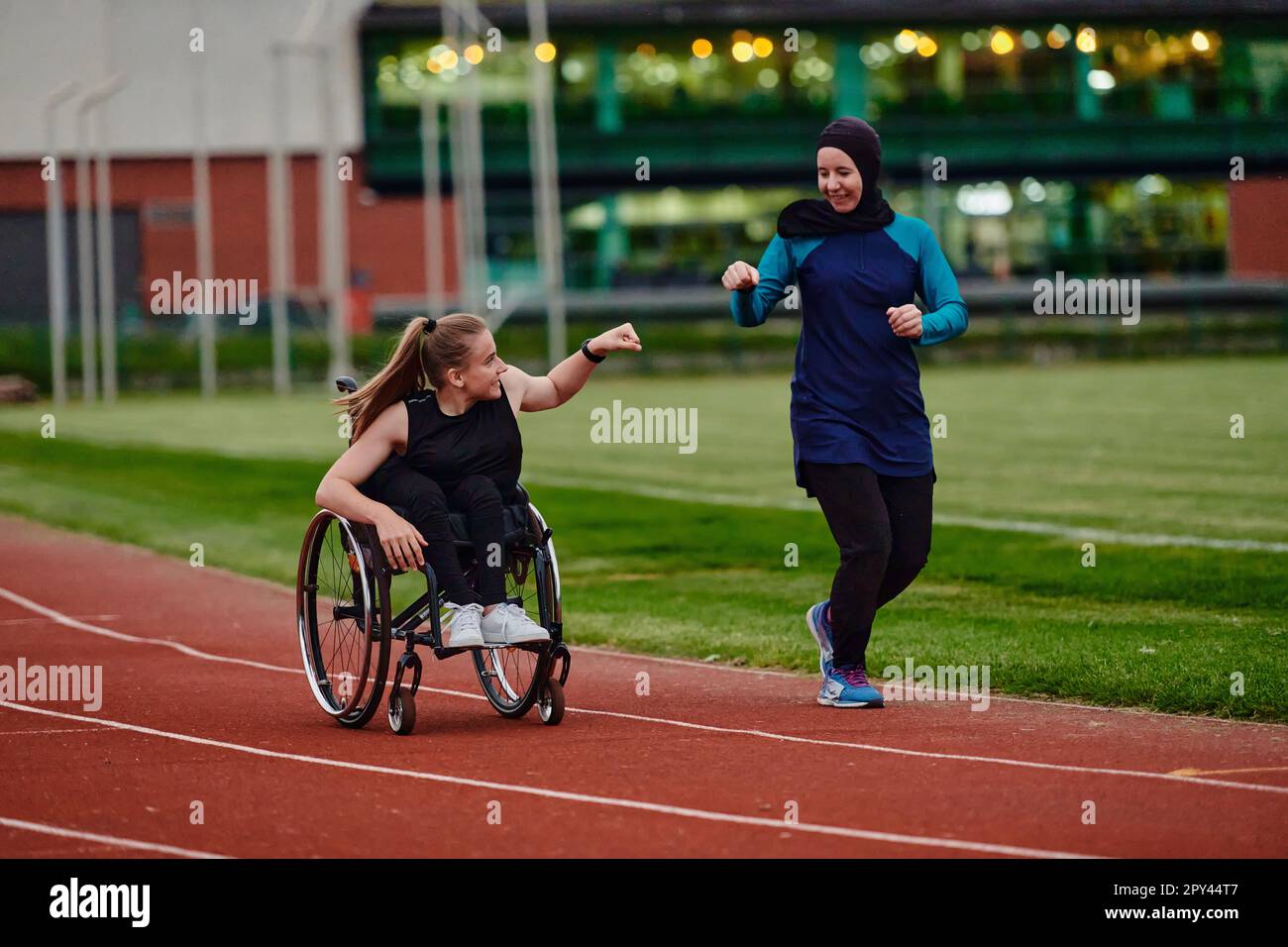 A Muslim woman wearing a burqa supports her friend with disability in a ...