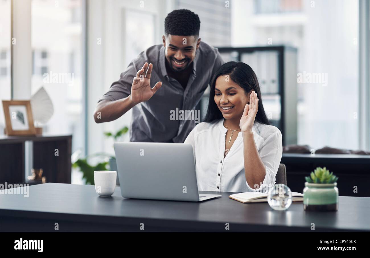 Greeting their clients across the globe. two businesspeople making a ...