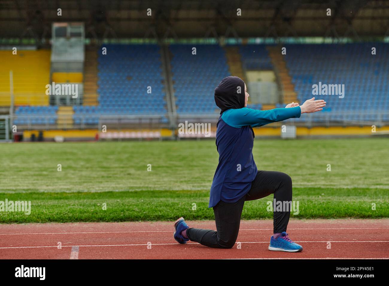 A Muslim woman in a burqa, an Islamic sports outfit, is doing body ...