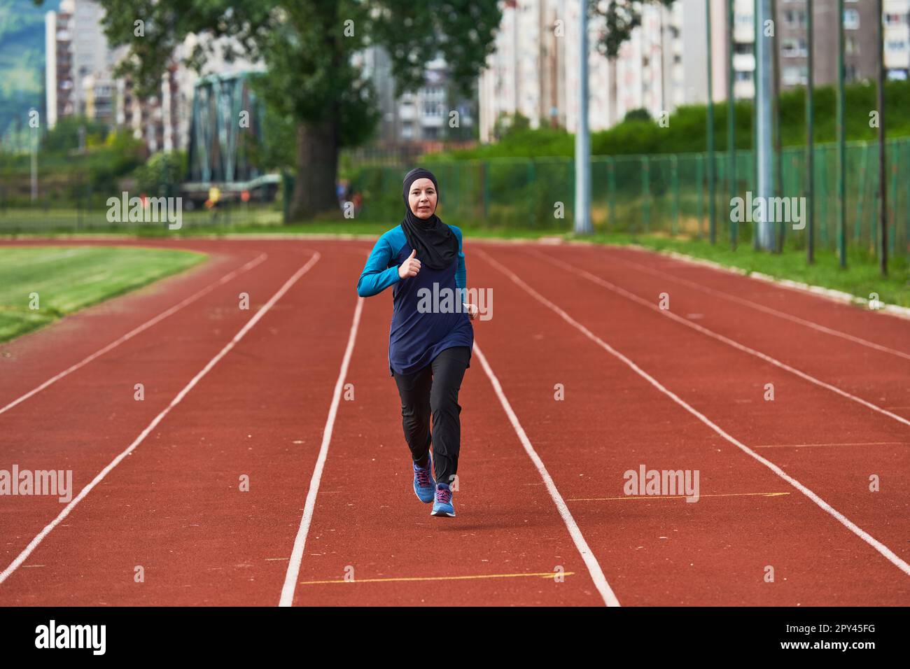 A muslim woman in a burqa sports muslim clothes running on a marathon ...
