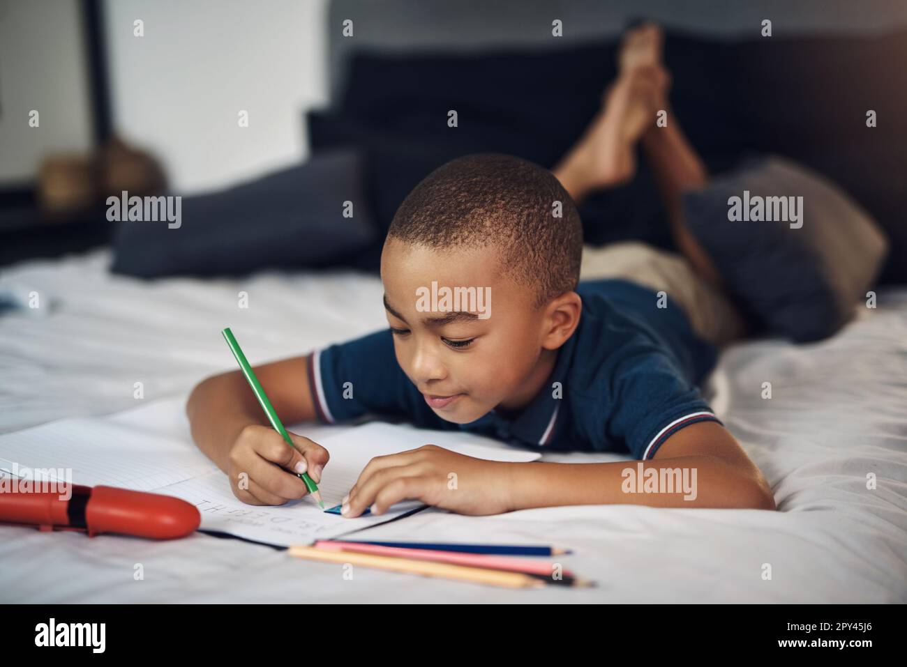 My teacher said I should practise my alphabet at home. a young boy ...