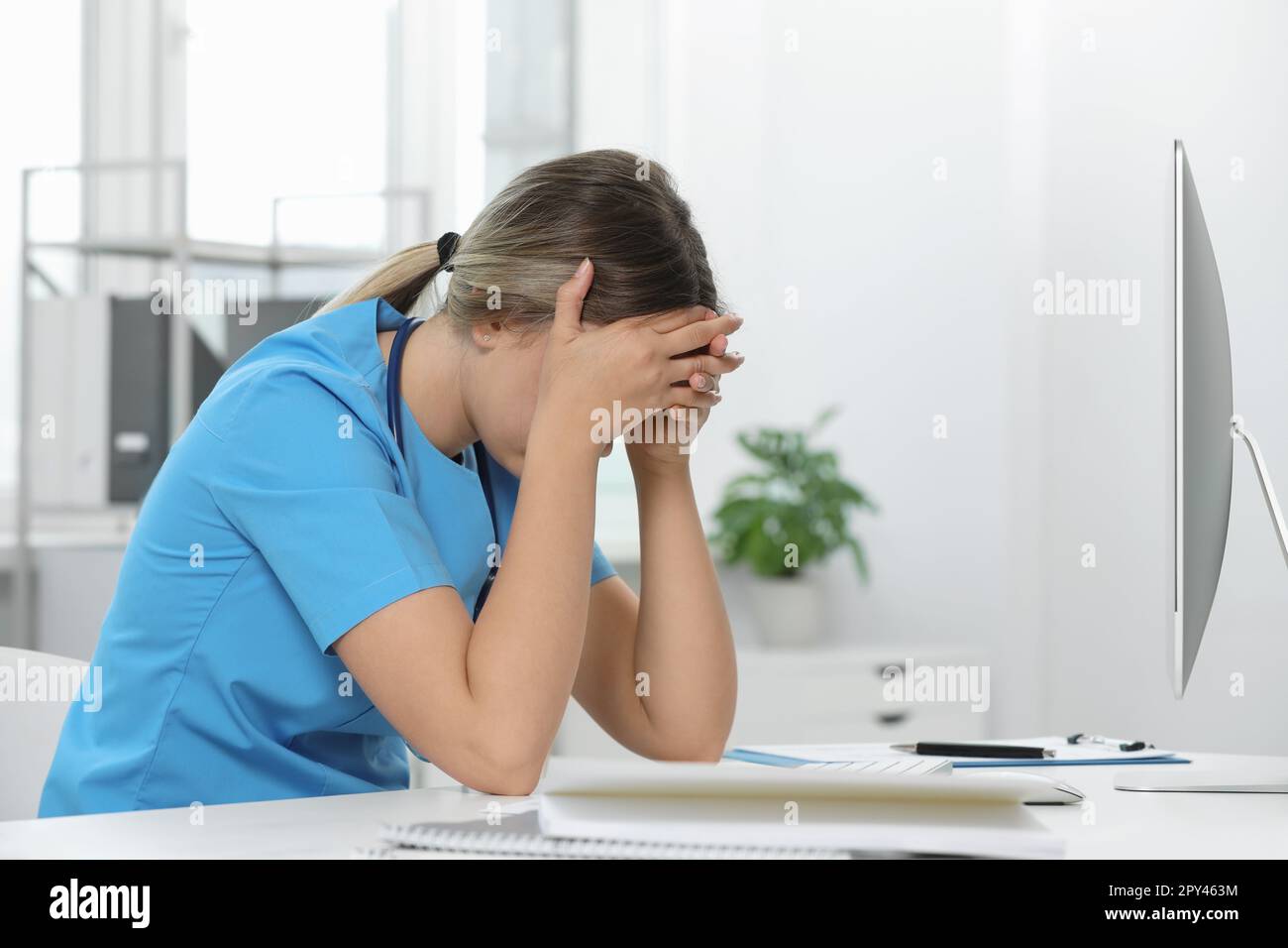 Exhausted doctor at workplace in hospital, space for text Stock Photo ...