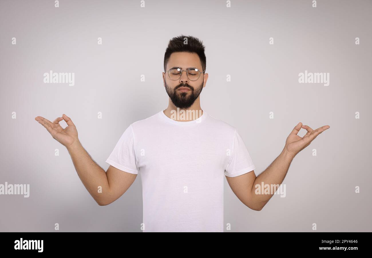Young man meditating on white background. Zen concept Stock Photo - Alamy