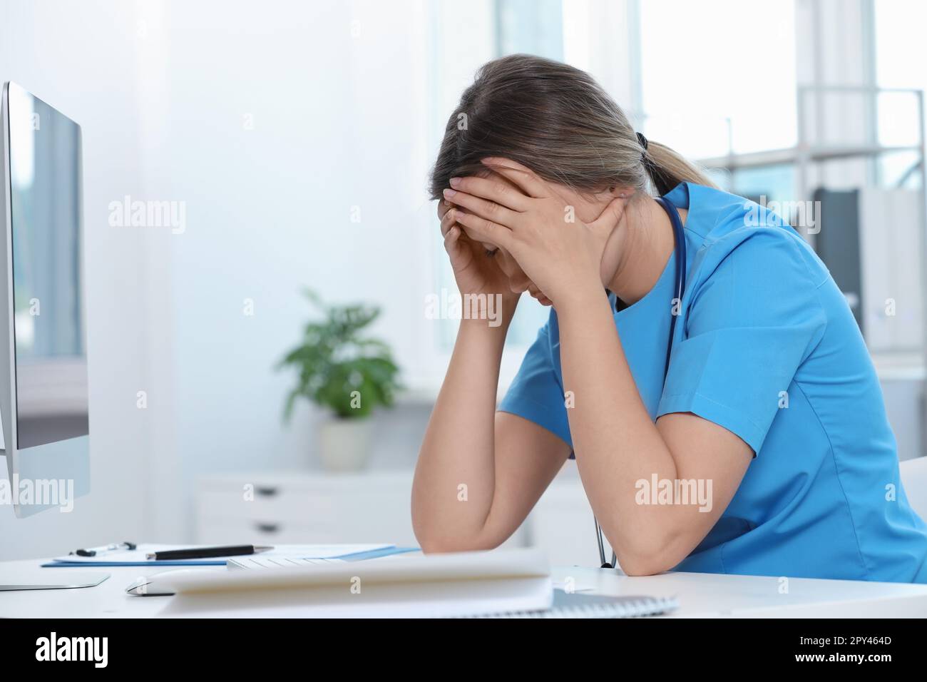 Exhausted doctor at workplace in hospital, space for text Stock Photo ...