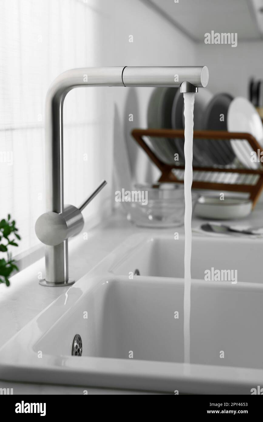 Stream of water flowing from tap in kitchen Stock Photo - Alamy