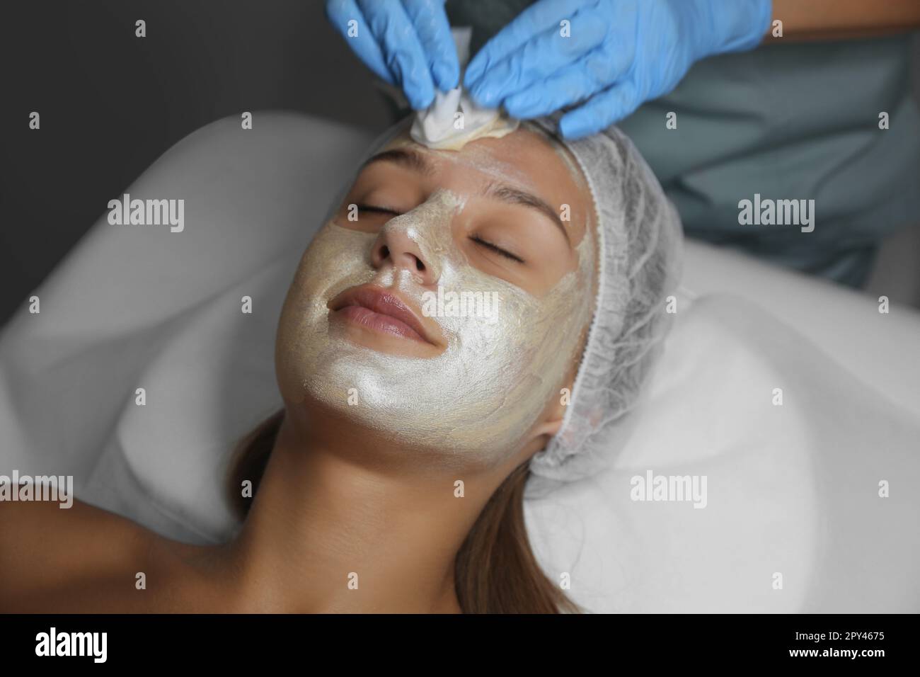 Cosmetologist removing mask from client's face in spa salon Stock Photo ...