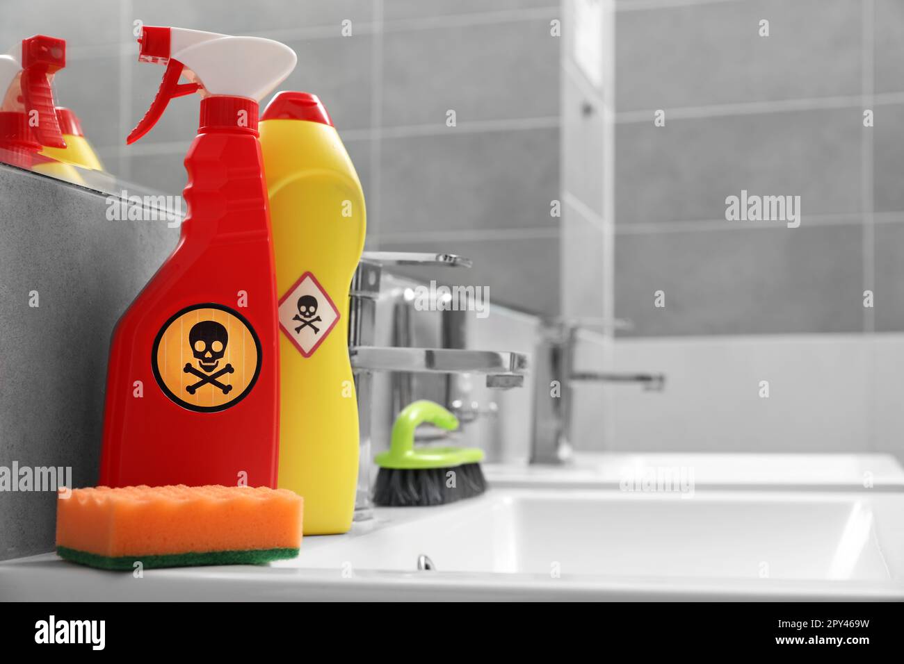 Bottles of toxic household chemicals with warning signs, brush and ...
