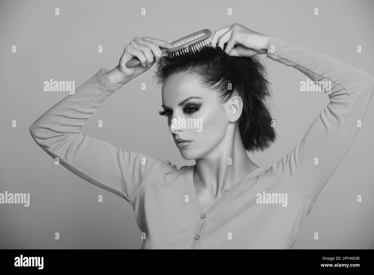 Woman combing hair. Portrait of female model with a comb brushing hair ...
