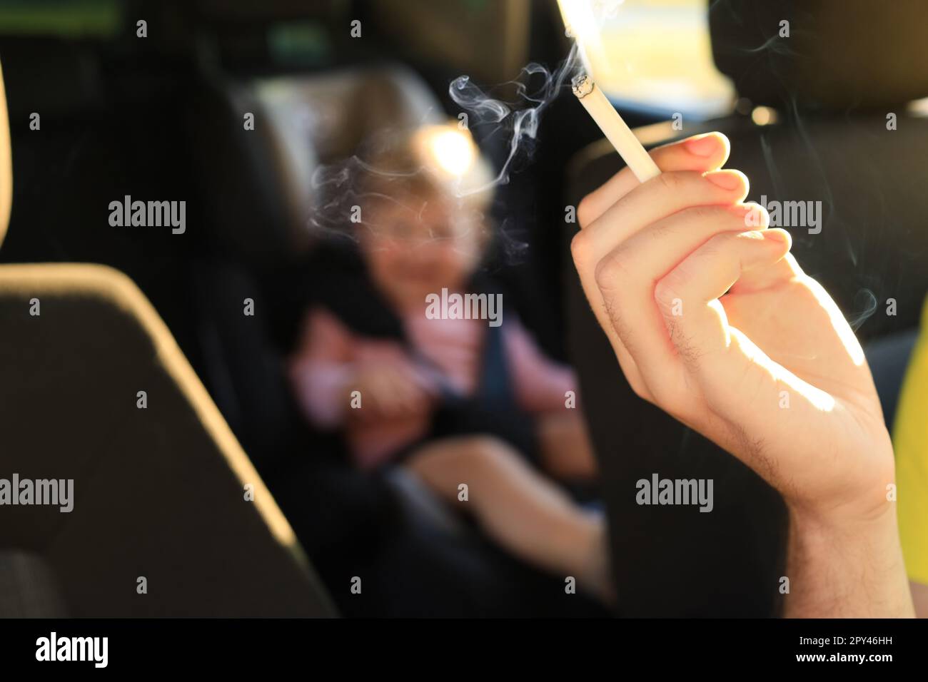 Mother with cigarette and child in car, closeup. Don't smoke near kids ...