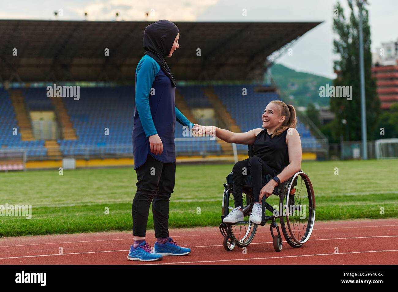 A Muslim woman wearing a burqa supports her friend with disability in a ...