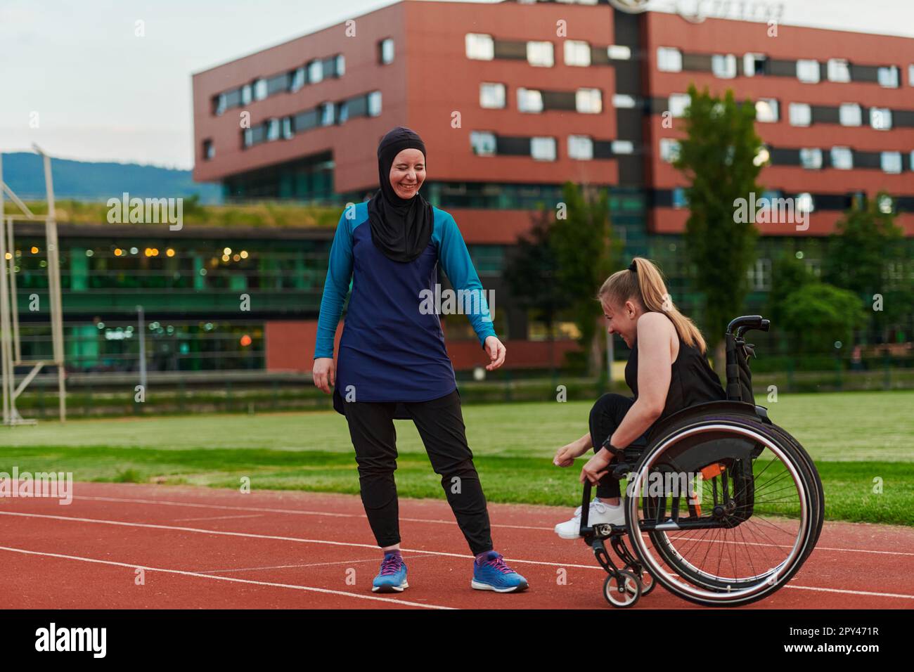 A Muslim woman wearing a burqa supports her friend with disability in a ...