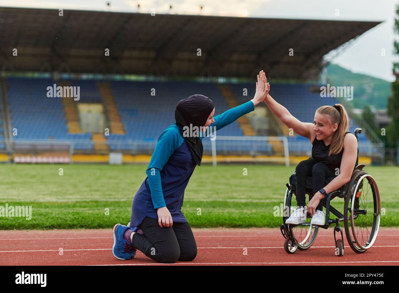 A Muslim woman wearing a burqa supports her friend with disability in a ...