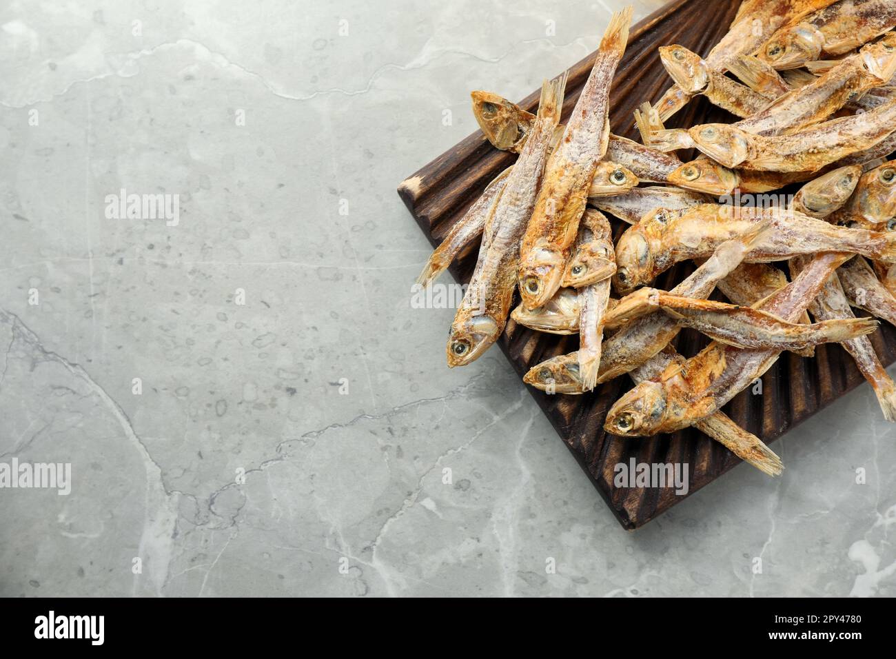Delicious dried anchovies on light grey marble table, top view. Space ...