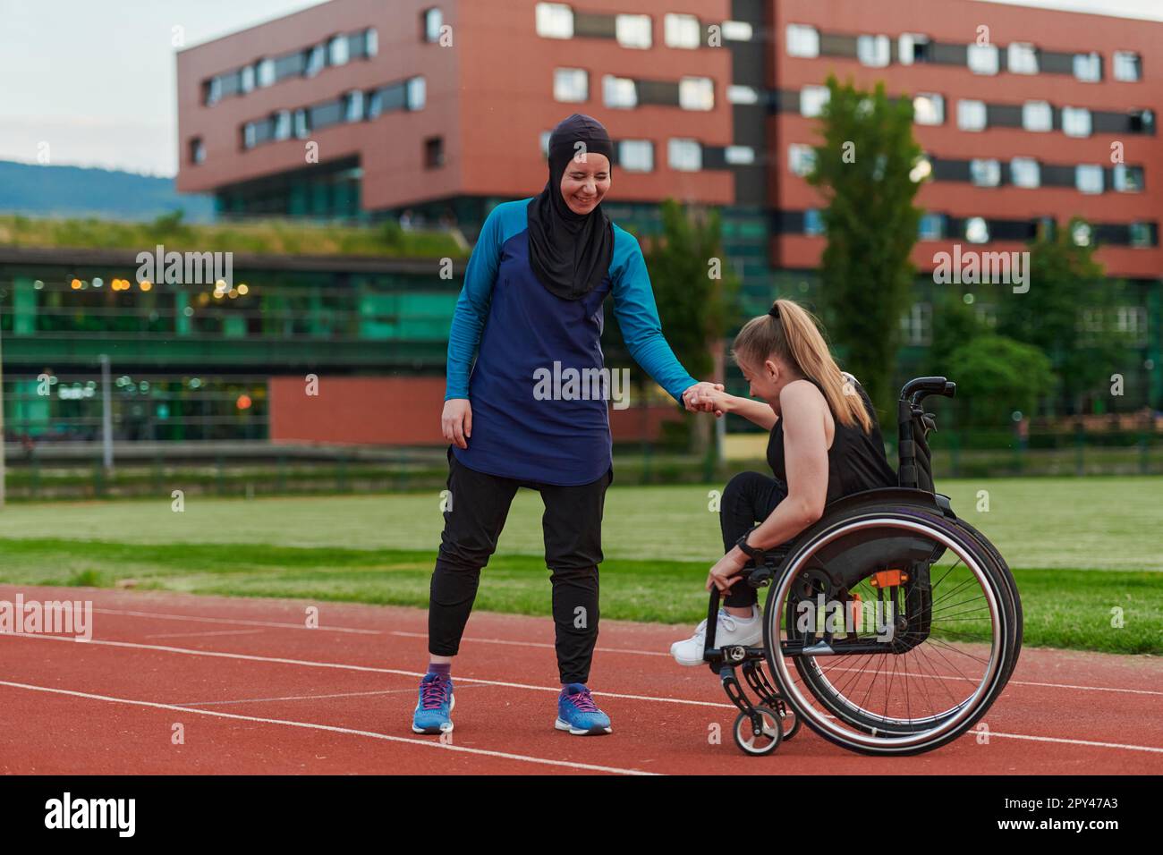 A Muslim woman wearing a burqa supports her friend with disability in a ...