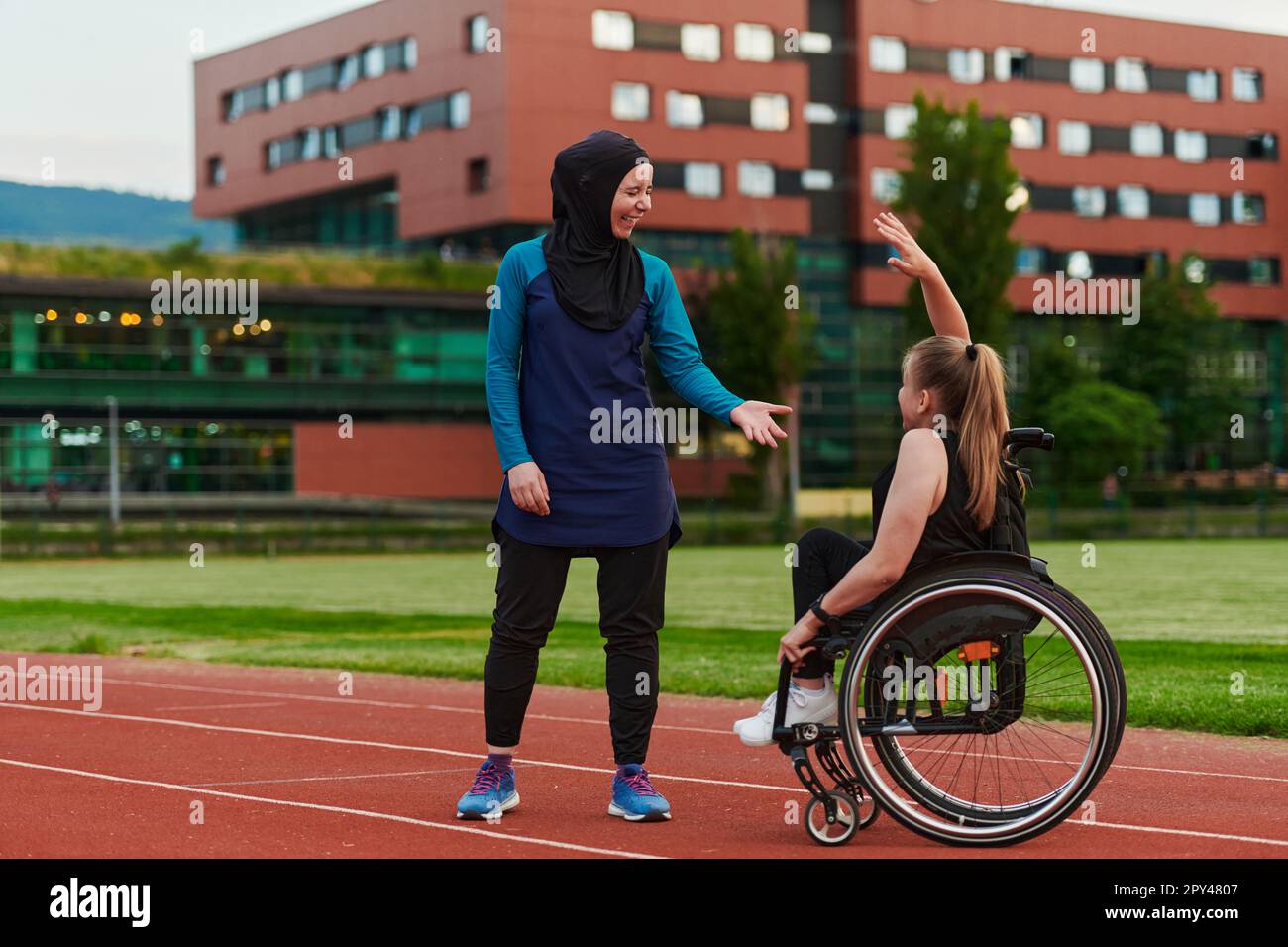 A Muslim woman wearing a burqa supports her friend with disability in a ...