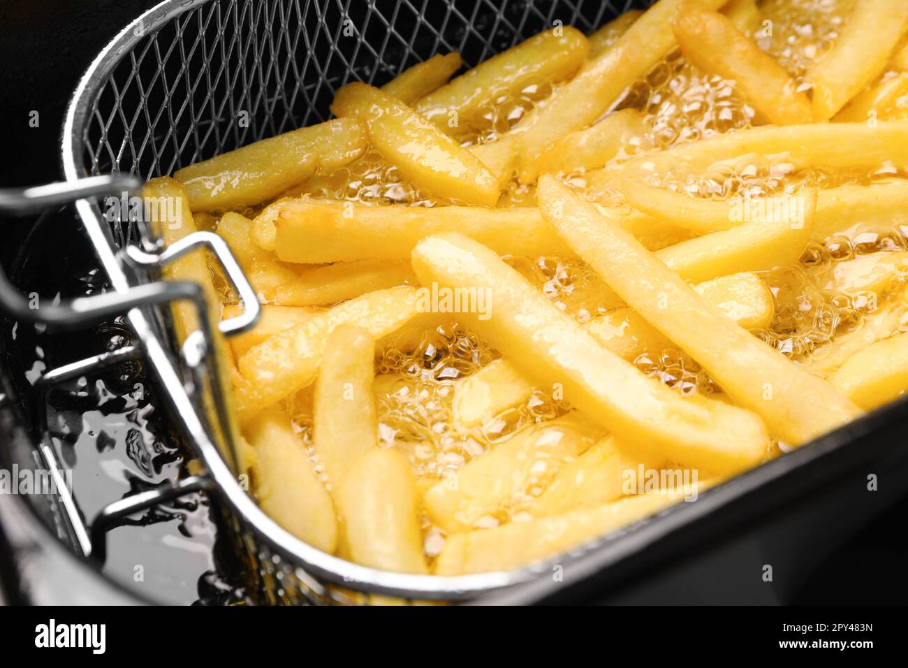 Cooking delicious french fries in hot oil, closeup Stock Photo - Alamy
